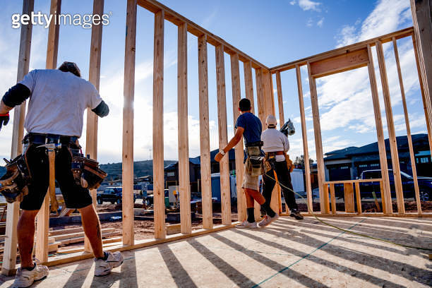 A Group Of Carpenters Setting Walls On A New Home Being Built In A New ...