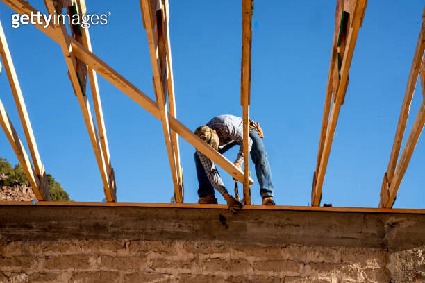 A Rugged Carpenter On A Framing Crew Setting Trusses (1205366565) - 게티이미지뱅크