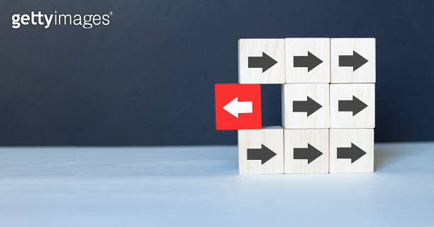 Wooden block with red arrow facing the opposite direction black arrows ...