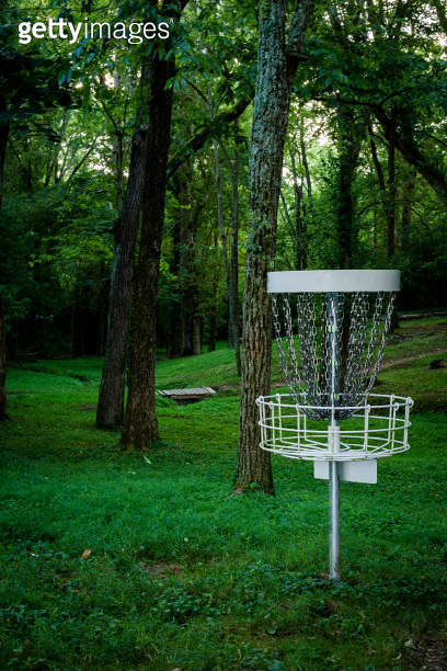 Disc Golf target in the park with mountain bike bridge in a distance ...