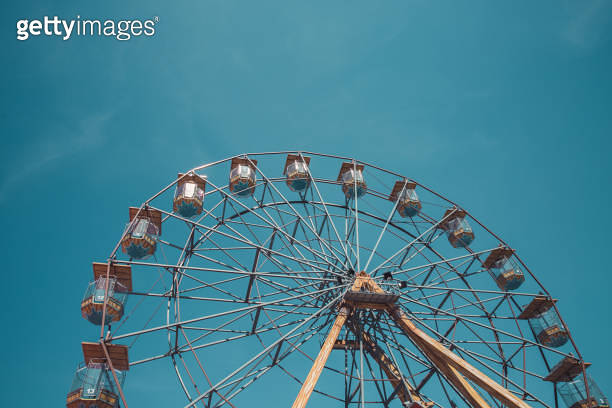A distant view of a vintage Ferris Wheel at a seaside fairground with ...
