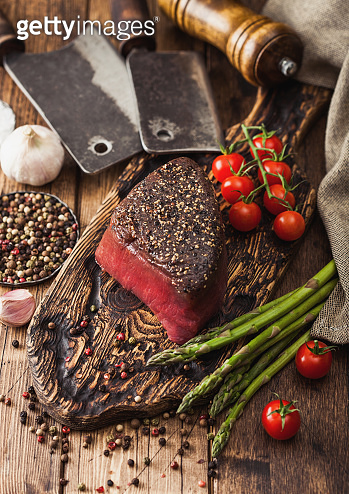 Slice of Raw Beef Topside Joint with Salt and Pepper on wooden chopping ...