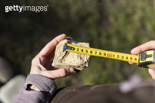 Personal Perspective Close-up of Geologist Measuring a Stone With Tape ...