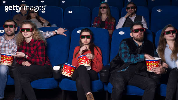 Loving couples hugging while watching a movie, and only a lonely girl ...
