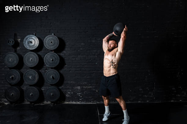 Young sweaty strong muscular fit man with big muscles doing ball ...