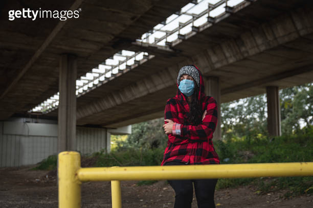 Young depressed homeless girl or woman with hood and protective ...