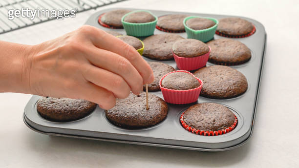 Chocolate cupcakes close up on baking pan. Chef checking cupcakes for ...