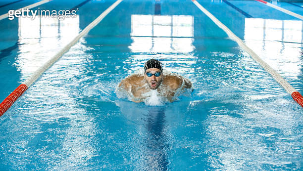 Swimming in motion. Swimmer demonstrates the butterfly stroke technique ...