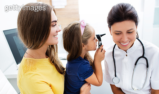 little girl who sitting in her mother's arms and looking through the ...