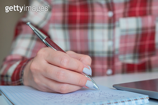 Close up: woman hand making notes during quarantine at home - self ...