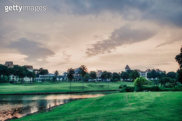 A golf course in melaka with sunset view in front of a lake with ...