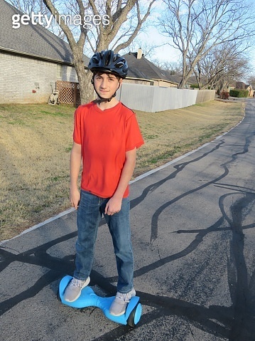 teenage boy riding hoverboard (gyroscooter) in residential street 이미지 ...