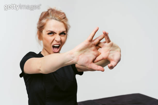 Combative mood! Young woman stretching her arms. Preparing to hard work ...