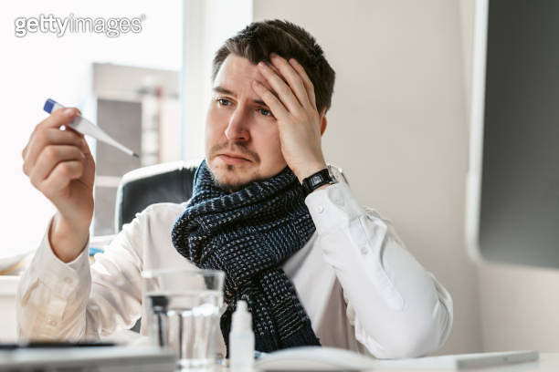 A young freelancer, businessman or office worker has a cold and flu. A ...