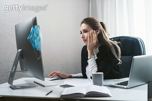 A young woman works in a home office during quarantine due to the ...