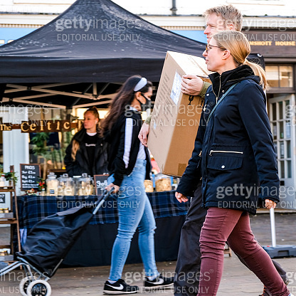 Young Couple Walking Together Carrying A Package Or Box During COVID-19 ...