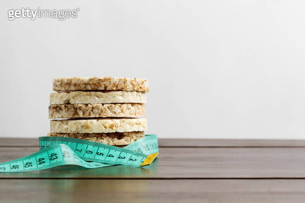 Rice and buckwheat cakes with a measuring tape on a wood table. 이미지 ...