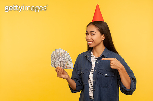 Portrait of rich successful happy woman pointing dollar banknotes and ...