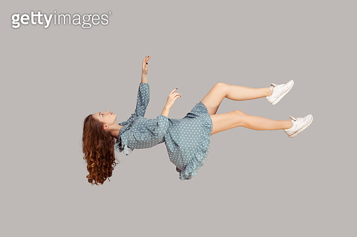 Floating in air. Relaxed girl in vintage ruffle dress levitating ...