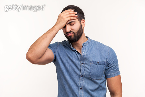 Upset frustrated man holding forehead with hand, making facepalm ...