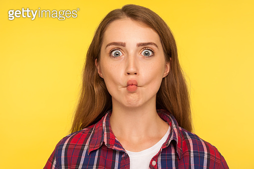 Portrait of amusing funny ginger girl in checkered shirt making fish ...