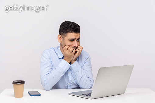 Nervous scared man employee sitting office workplace, looking worried ...