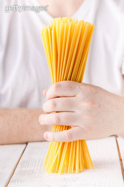 Hand full of raw dry spaghetti, close up view 이미지 (1221478632) - 게티이미지뱅크