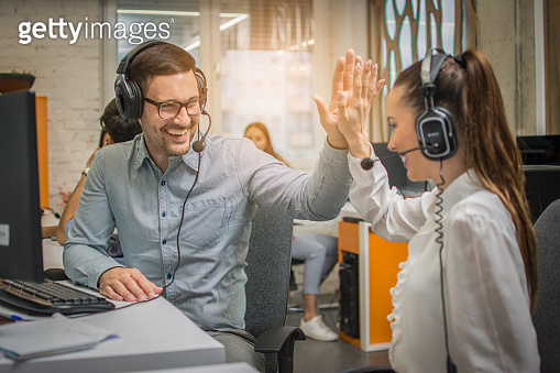 Call center operators giving high five to each other, celebrating ...