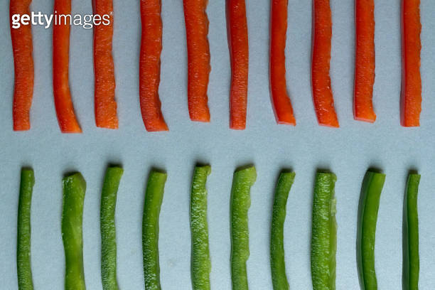 Red and green bell pepper sticks on modern blue kitchen countertop ...