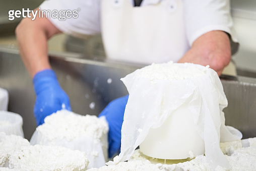 Man mixing milk in the stainless tank during the fermentation process ...