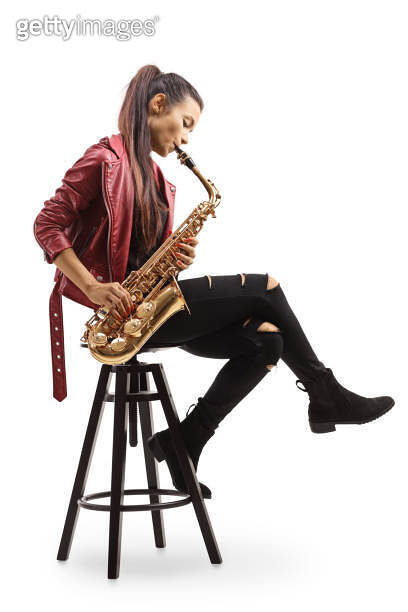 Female musician sitting on a chair and playing a saxophone 이미지 ...