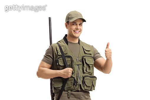 Young hunter with a shotgun on his shoulder showing thumbs up sign ...