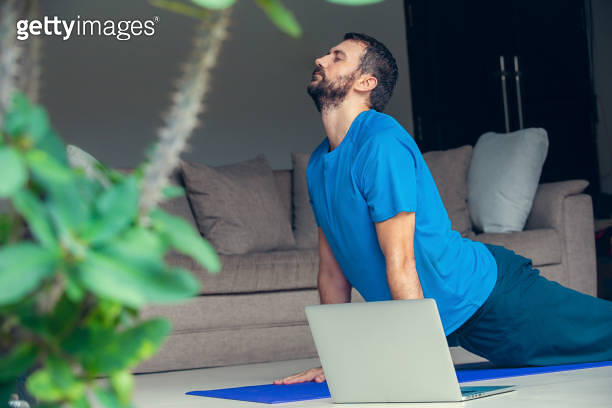 Man practicing yoga at home with online yoga class. Fitness training ...