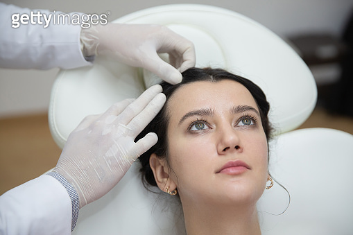 Doctor trichologist examining womans hair scalp for eczema, dermatitis ...