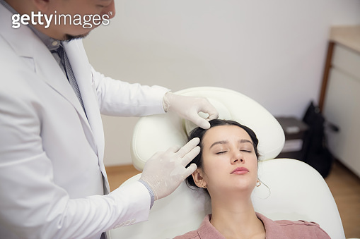 Doctor trichologist examining womans hair scalp for eczema, dermatitis ...