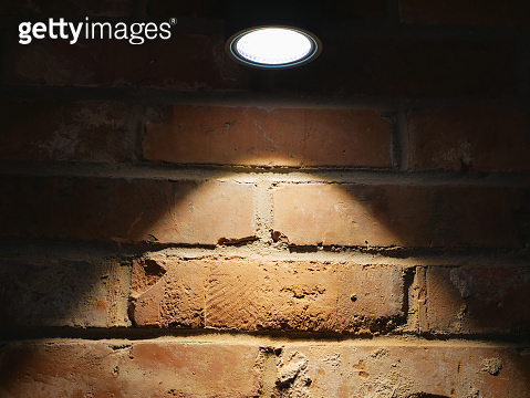 The brick wall is lit by a lamp. Close-up. Brick wall for background ...