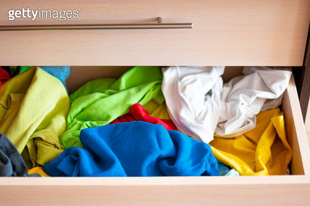 An open cabinet drawer with children's colorful things. Clutter in the ...