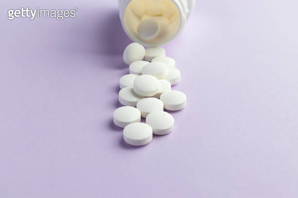 White capsules from a bottle on a lilac background. Epidemic ...