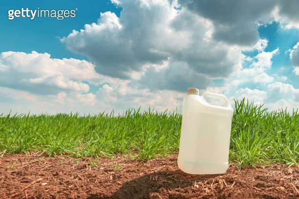 Blank pesticide jug container mock up in wheatgrass field (1197704318 ...