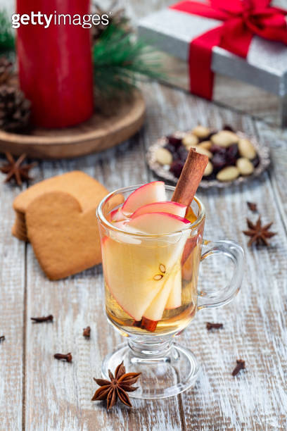 Glass of white glogg or mulled wine with apple slices and cinnamon ...