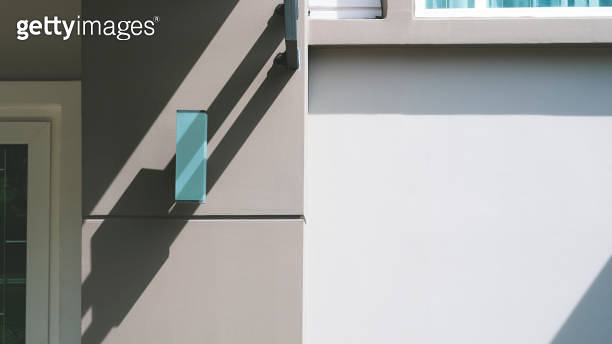 Sunlight and shadow on surface of rectangular glass lantern on cement ...