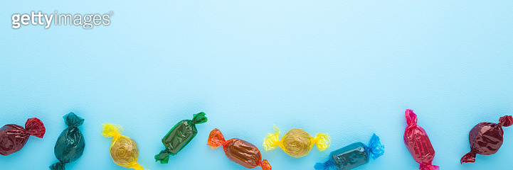 Colorful wrapped chocolate candies on light blue table background ...