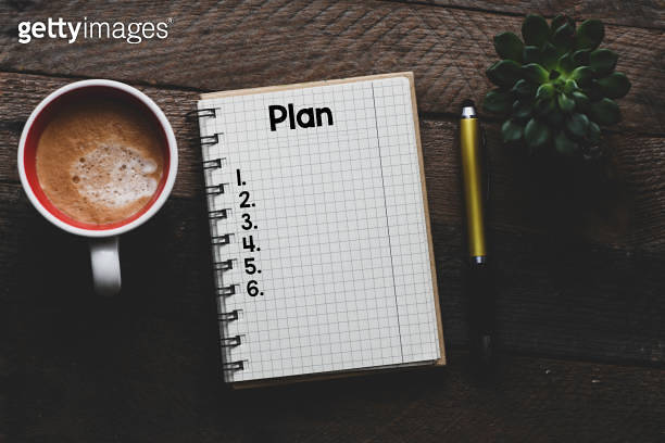 Plan text concept. The text "plan" written in a notebook on a wooden ...