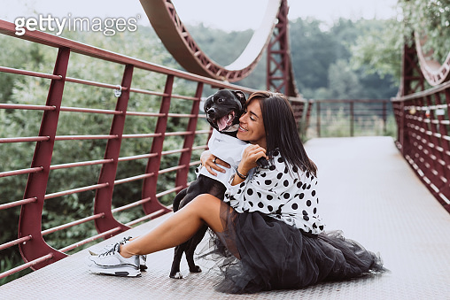 A beautiful young woman in a fluffy skirt and a polka-dot blouse sits ...