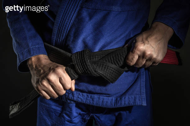 Close up on hand of unknown caucasian man holding brazilian jiu jitsu ...