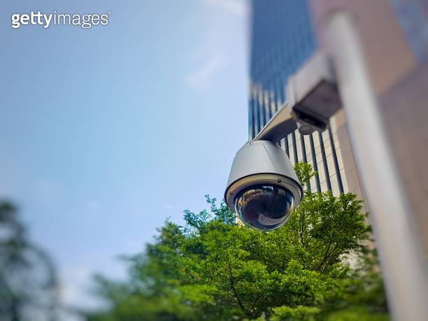 Security surveillance camera in front of office building walk way ...