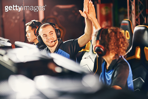 Winning. Two young happy professional cyber sport gamers giving high ...