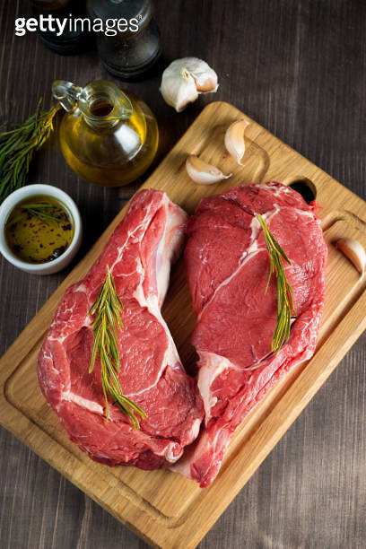 Raw fresh meat, beef and pork steak, ribeye, with rosemary, pepper and ...