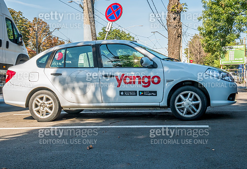 Yango logo inscribed on a white painted car. Yango ride sharing or ...