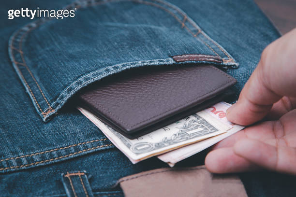 The man hand picking up the money in the wallet that put in the jeans ...